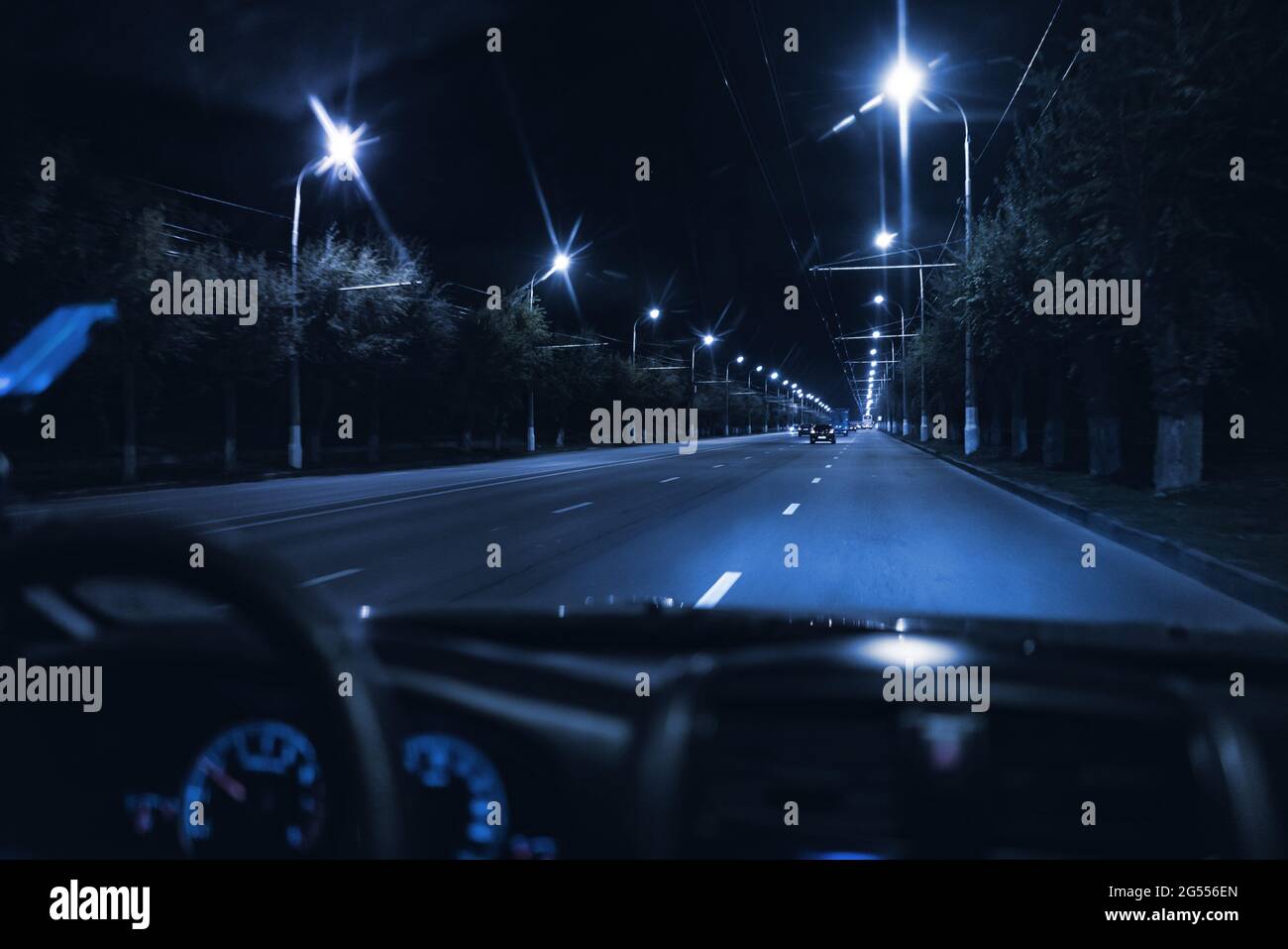 view from inside the car driving at night in the city traffic highway ...