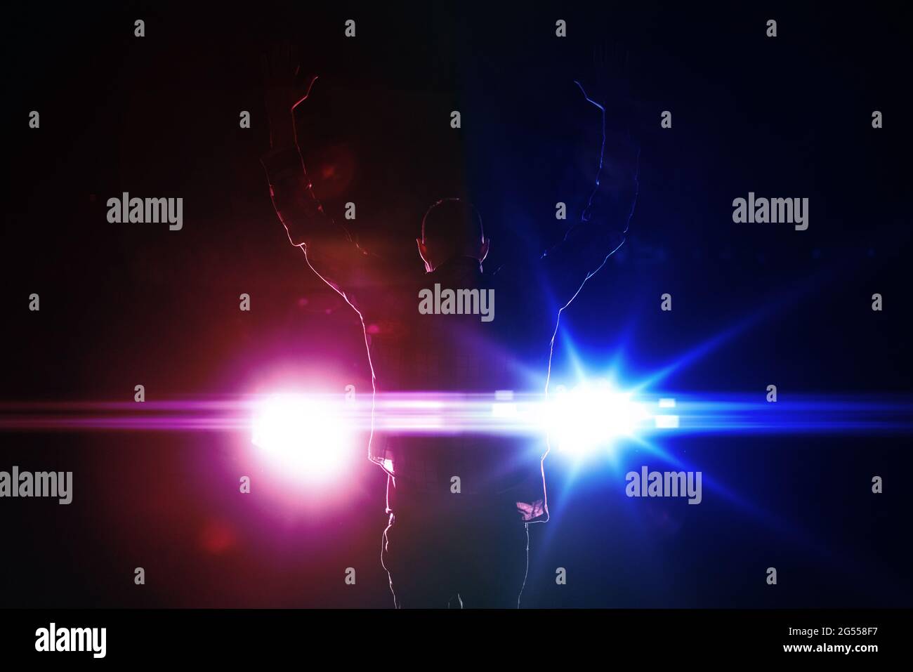 silhouette of a male criminal suspect with hands up during night ...