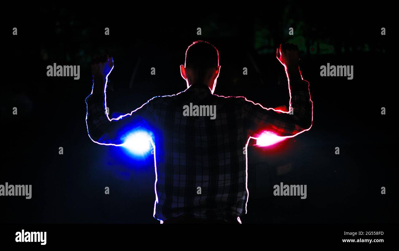 silhouette of a male criminal suspect with hands up during night ...