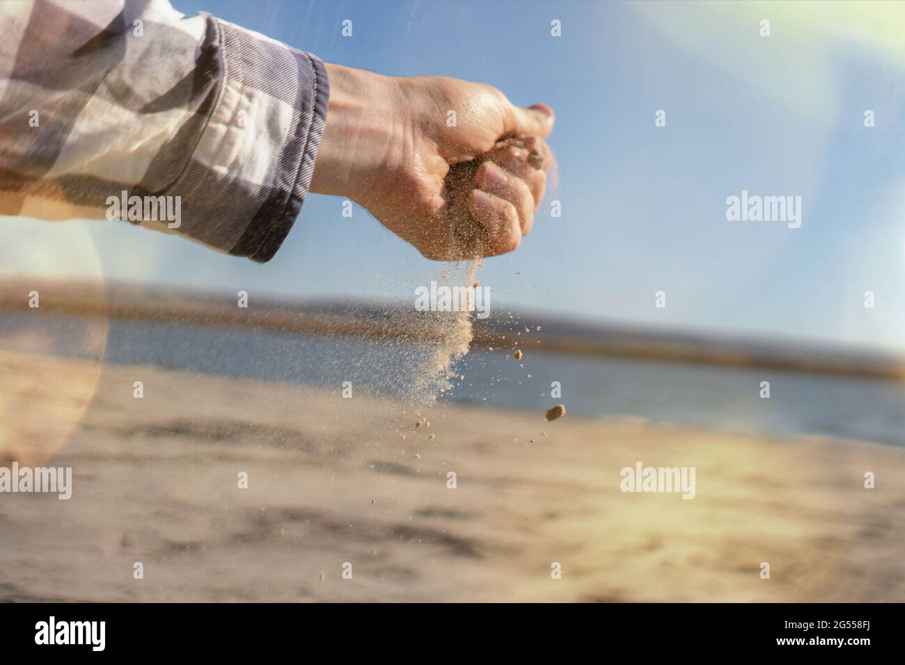 the hand pouring the sand on the beach as the symbol of disappointment ...