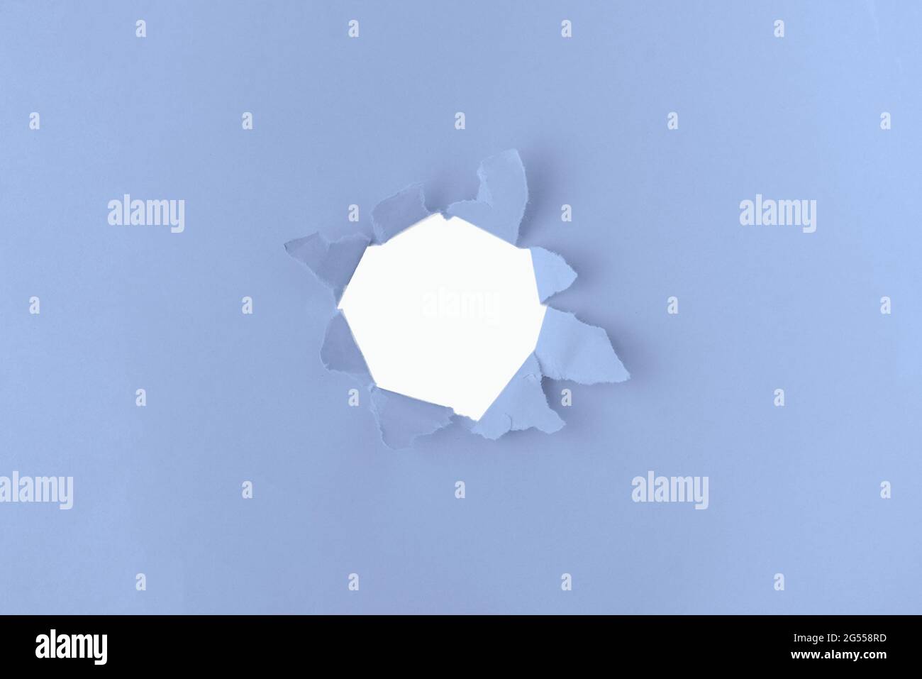 isolated piece of paper with a torn, cracked hole on it, copy space ...