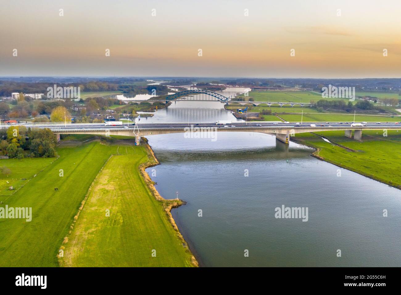 Aerial view of huge lowland river IJssel with highway and railroad ...