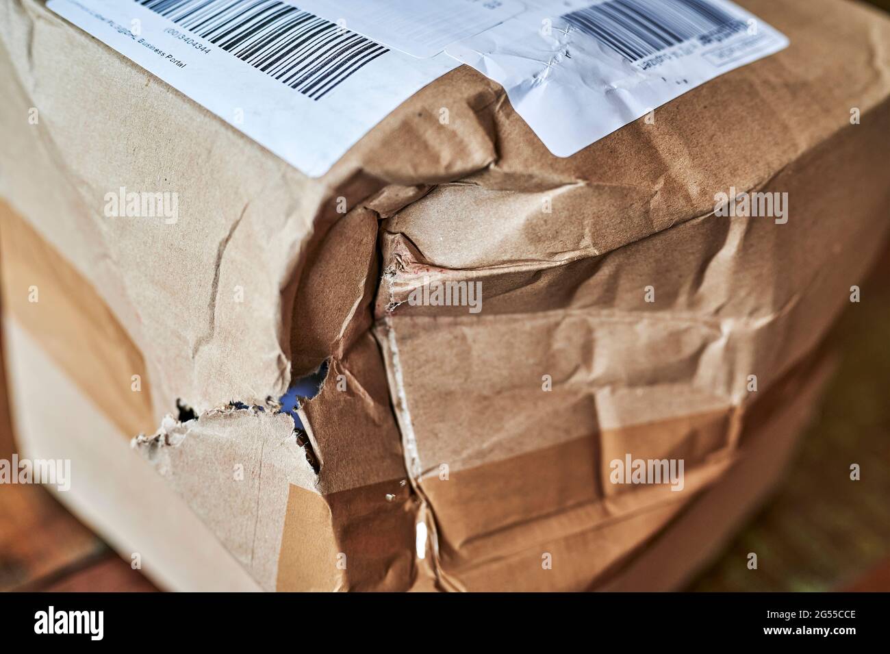 Cardboard package that was damaged in shipping and has a crack and ...
