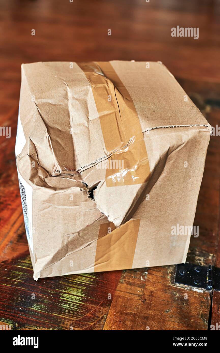 Cardboard package that was damaged in shipping and has a crack and ...