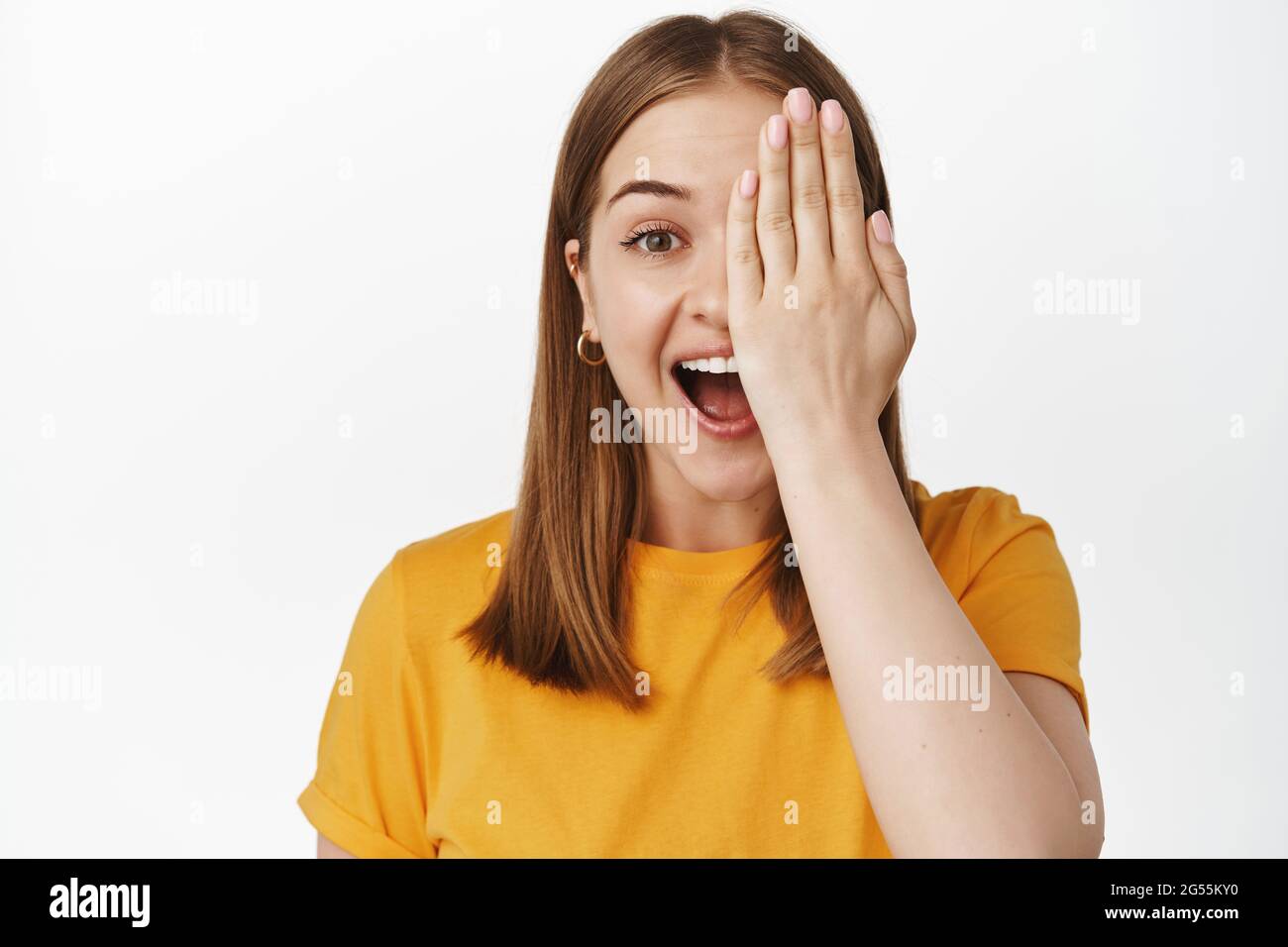 Portrait of happy young woman cover half of face, laughing and smiling ...