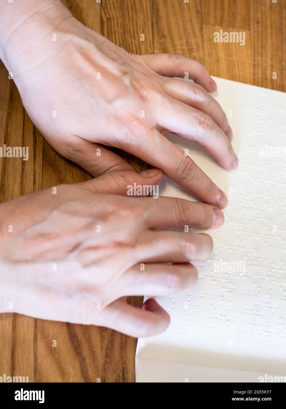 above view of female fingers reading book with braille closeup on ...