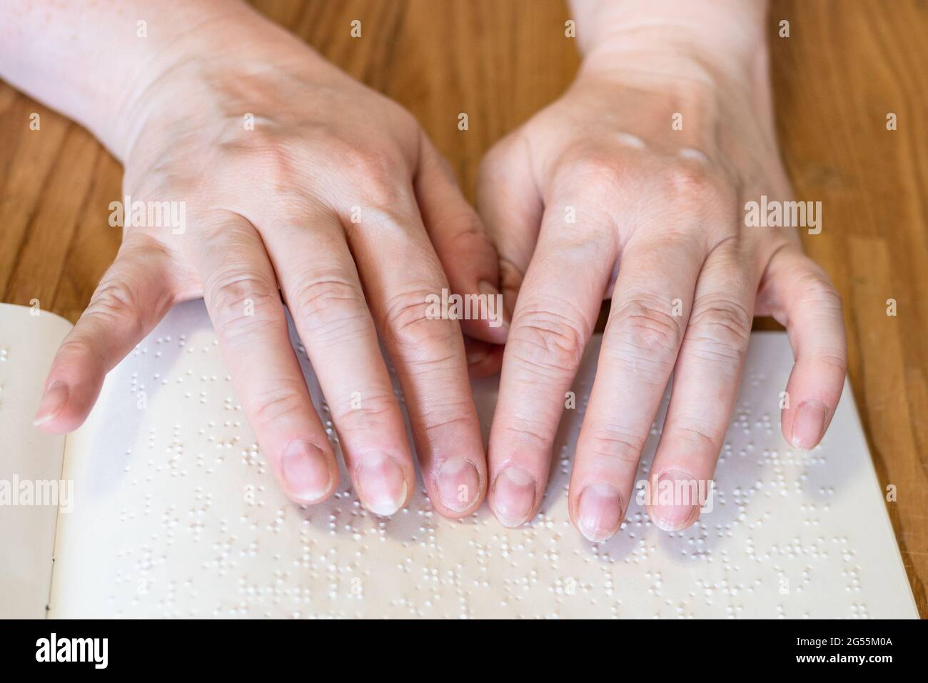 front view of female fingers reading book with braille closeup on ...