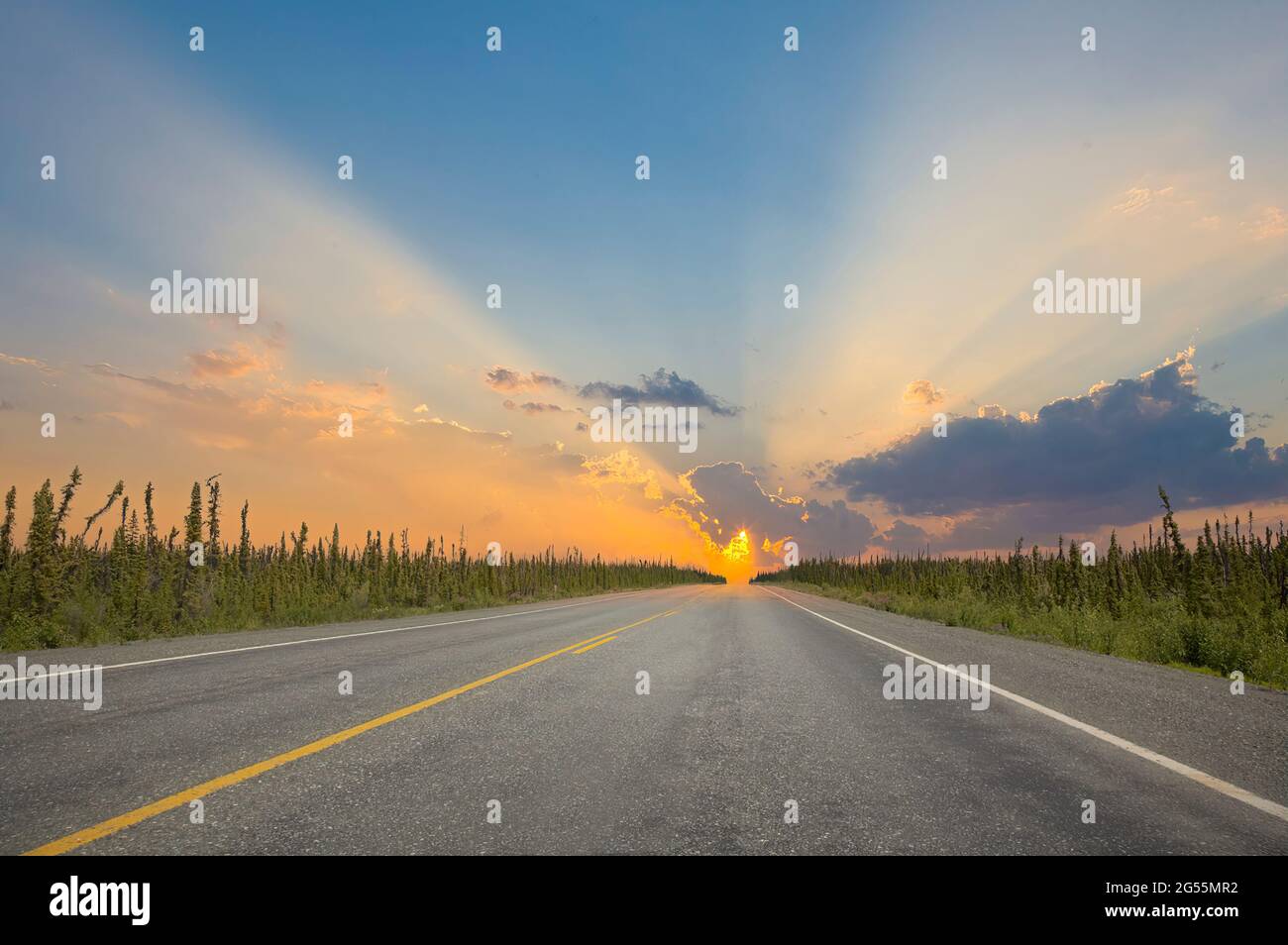 Looking down long straight flat Glenn Highway (Route 1) at sunset sky ...