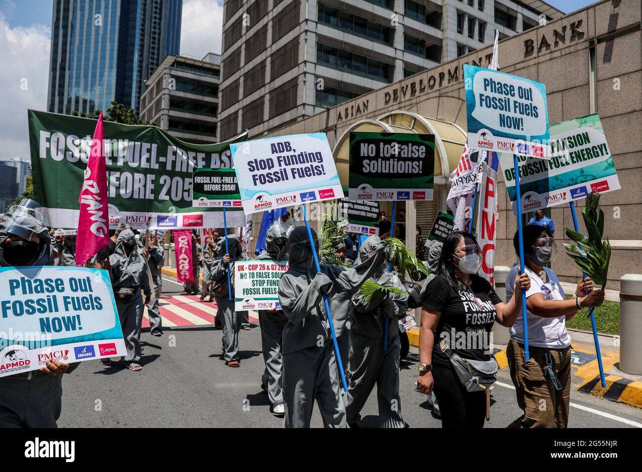 Climate activists dressed in PPE suits protest outside the Asian ...