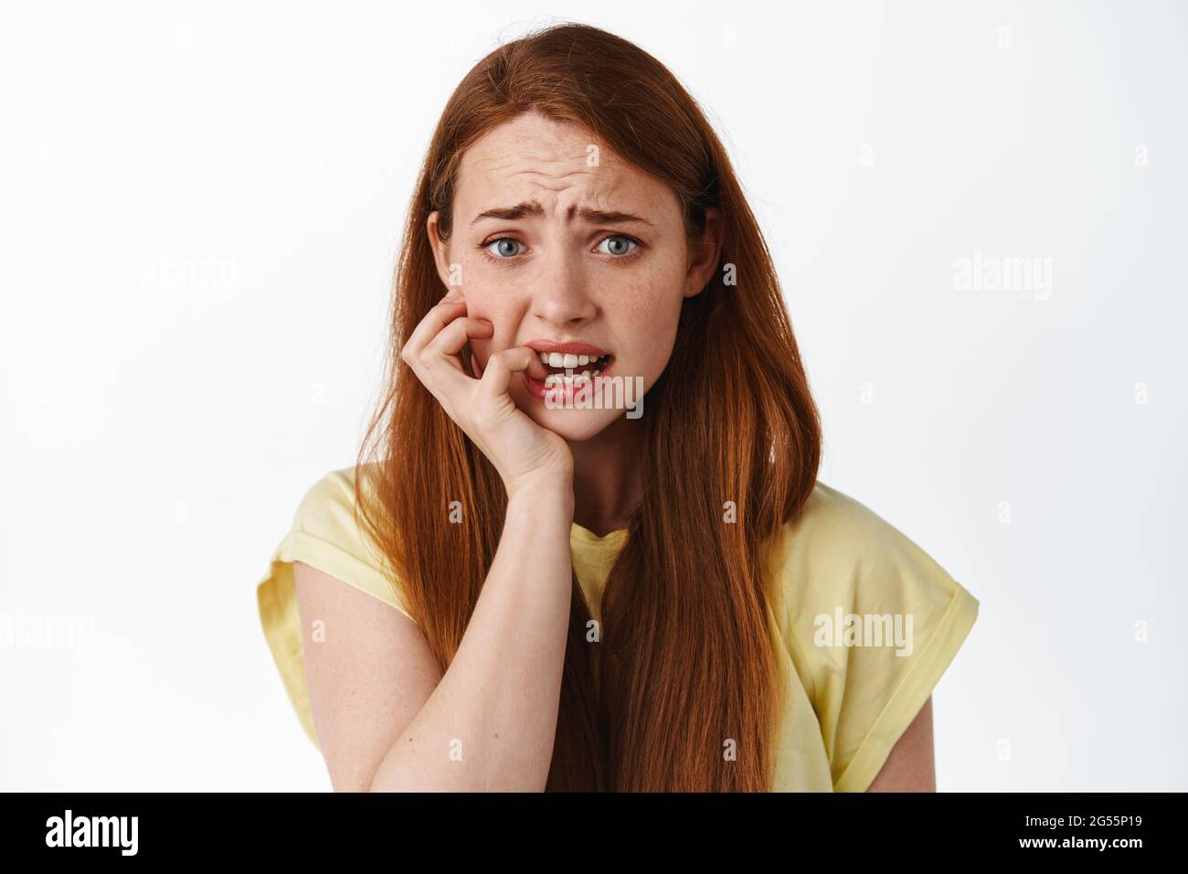 Close up portrait of anxious and scared girl student biting fingers ...