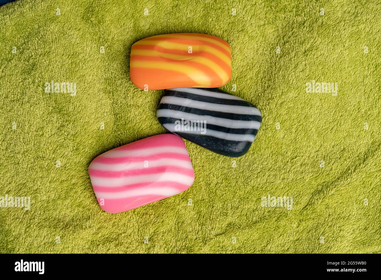 three pieces of striped soap bars on the towel textile texture, spa and ...