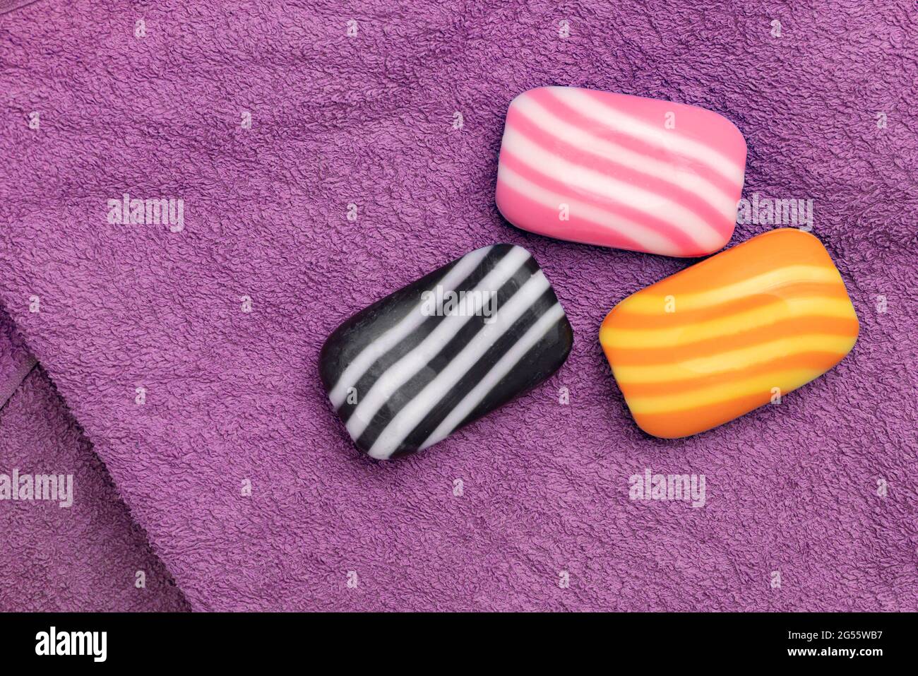 three pieces of striped soap bars on the towel textile texture, spa and ...