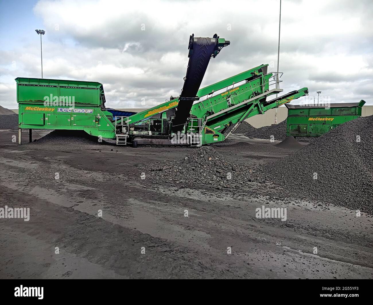 Mechanized loading of bulk cargo. Heaps of gravel on the dock and a ...