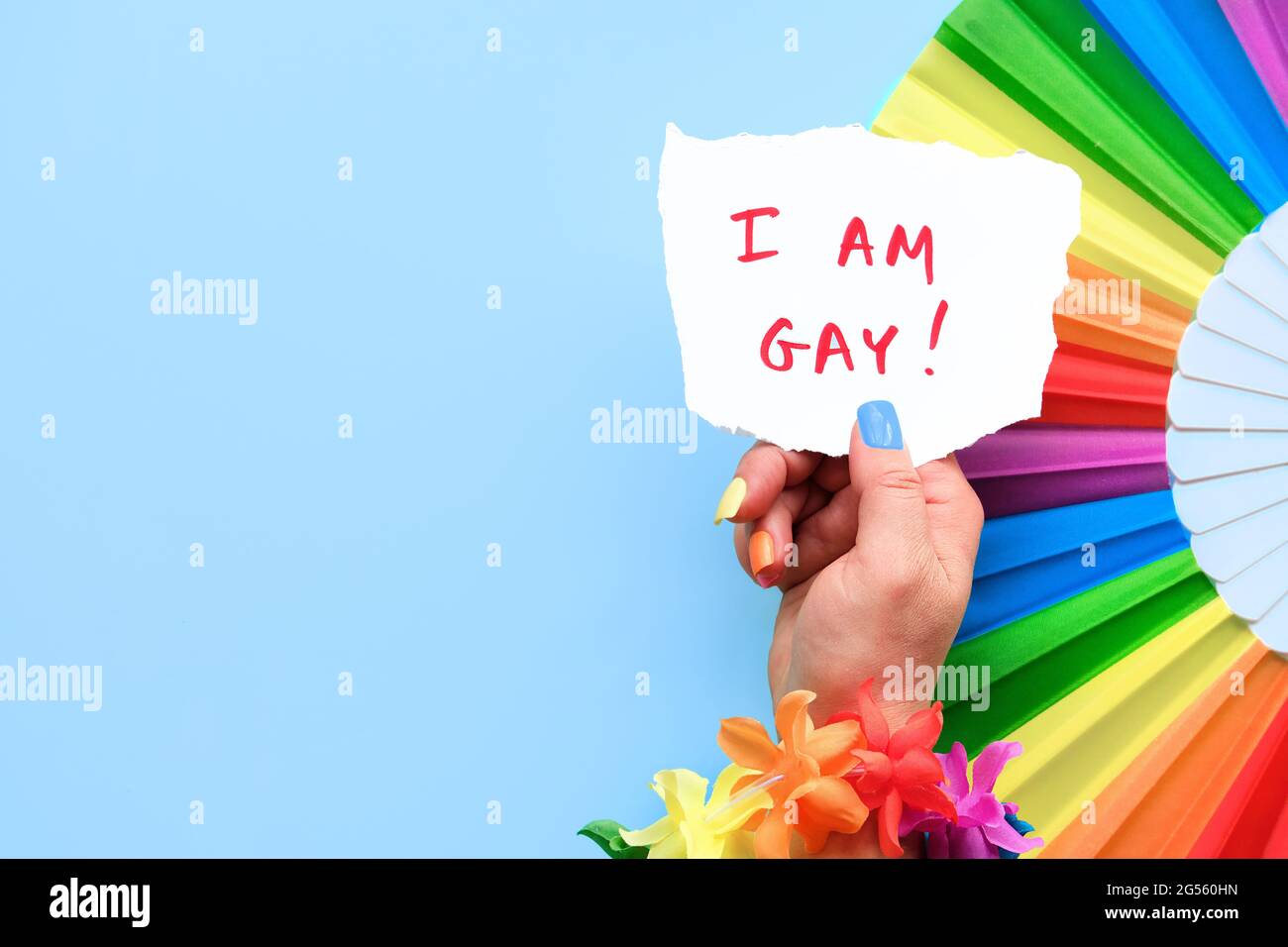 Text I am Gay on paper in hand with rainbow fan. LGBTQ community pride ...