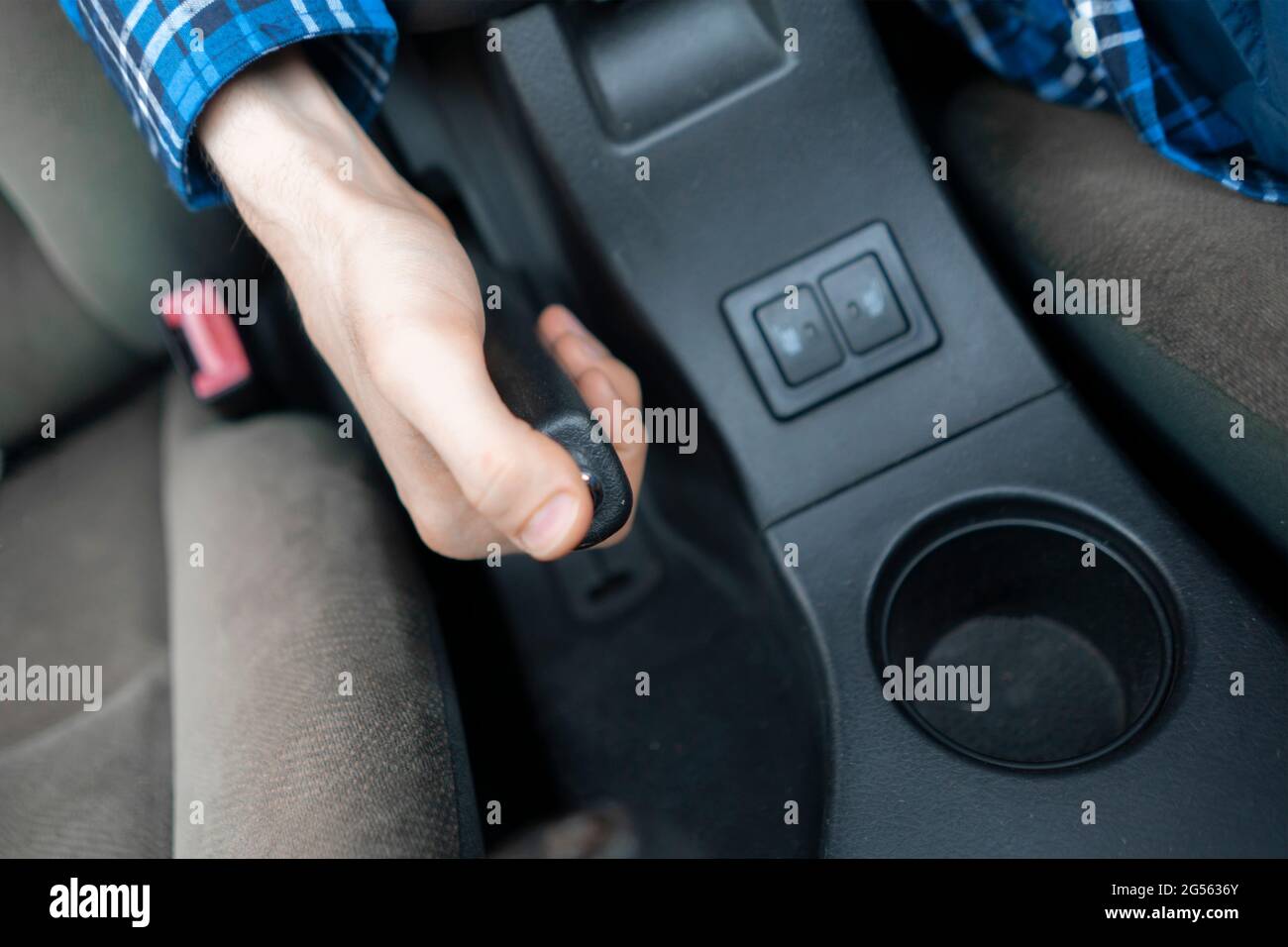 close up cropped hand using the handbrake, driver sitting inside the ...
