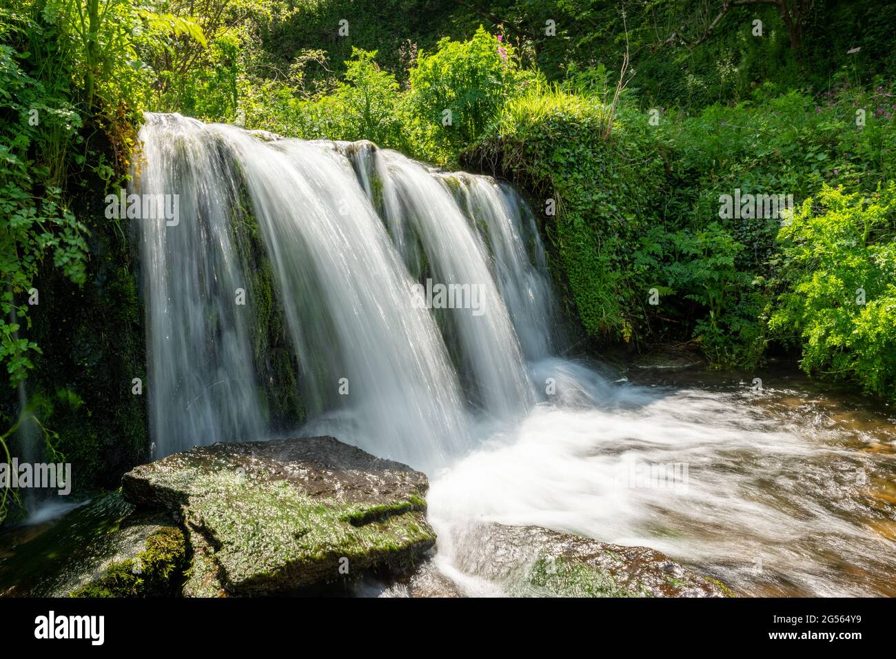 Long exposure of a waterfall flowing onto Lee Abbey Beach in Devon ...
