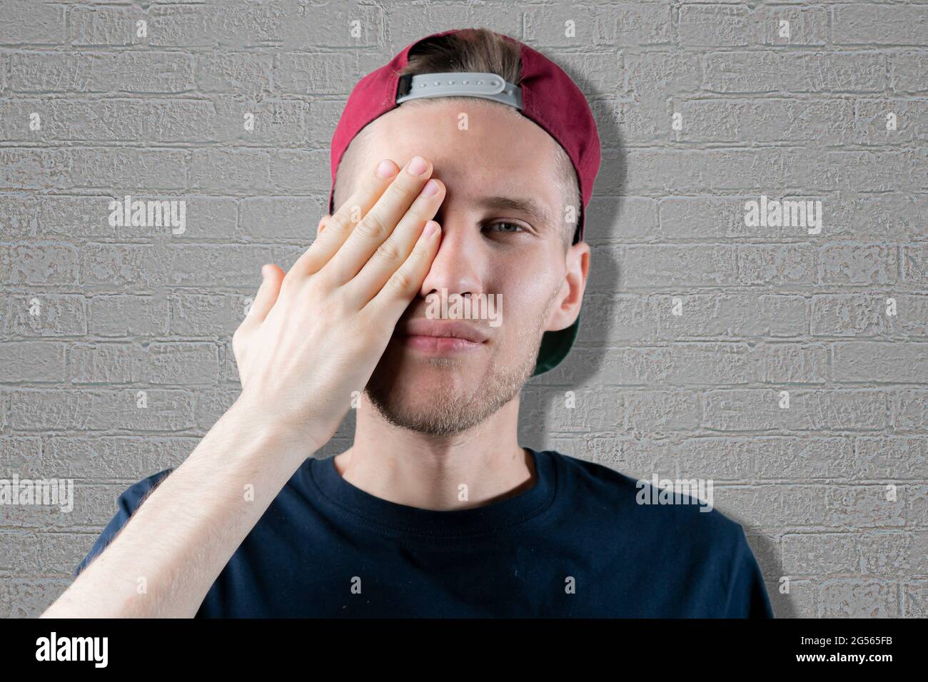 the male person closes his eye with his hand, abstract happy face ...