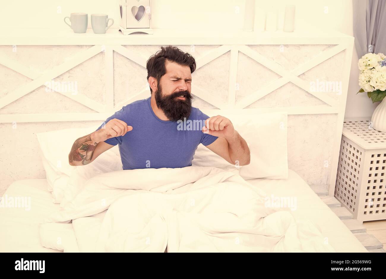 caucasian man with beard lying on bed after sleep at bright room ...