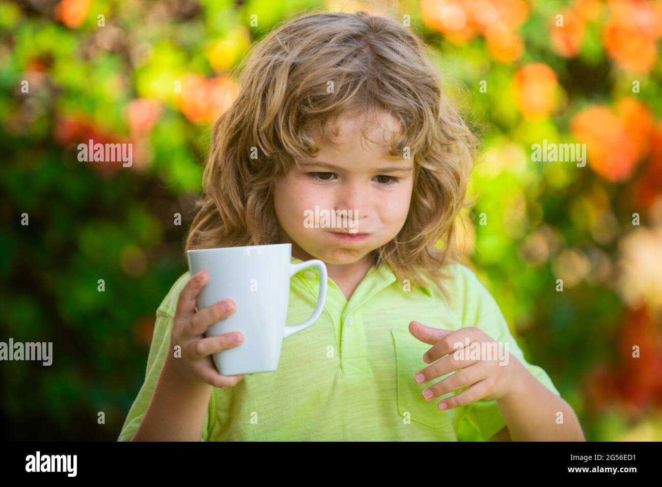 Child drinking tea or water in backyard garden. Healing kids and ...