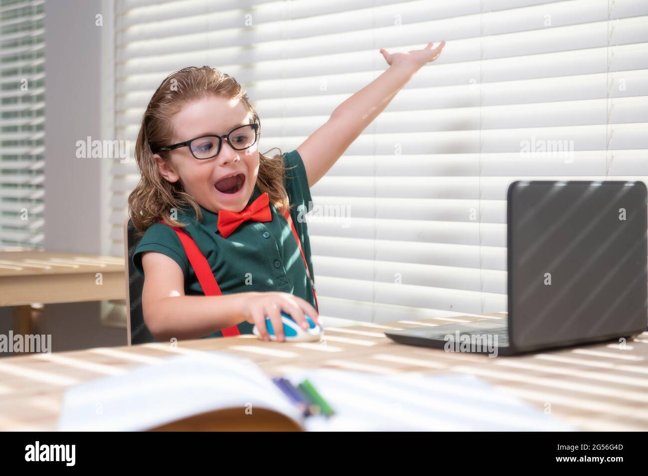 Smart school boy at home writing homework. Little student with notebook ...
