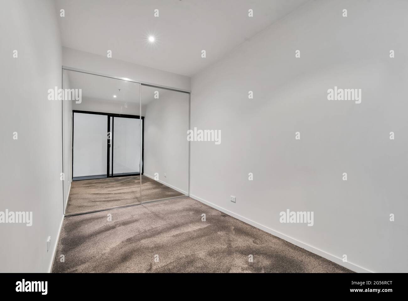 Empty room with gray walls and a large mirror Stock Photo - Alamy