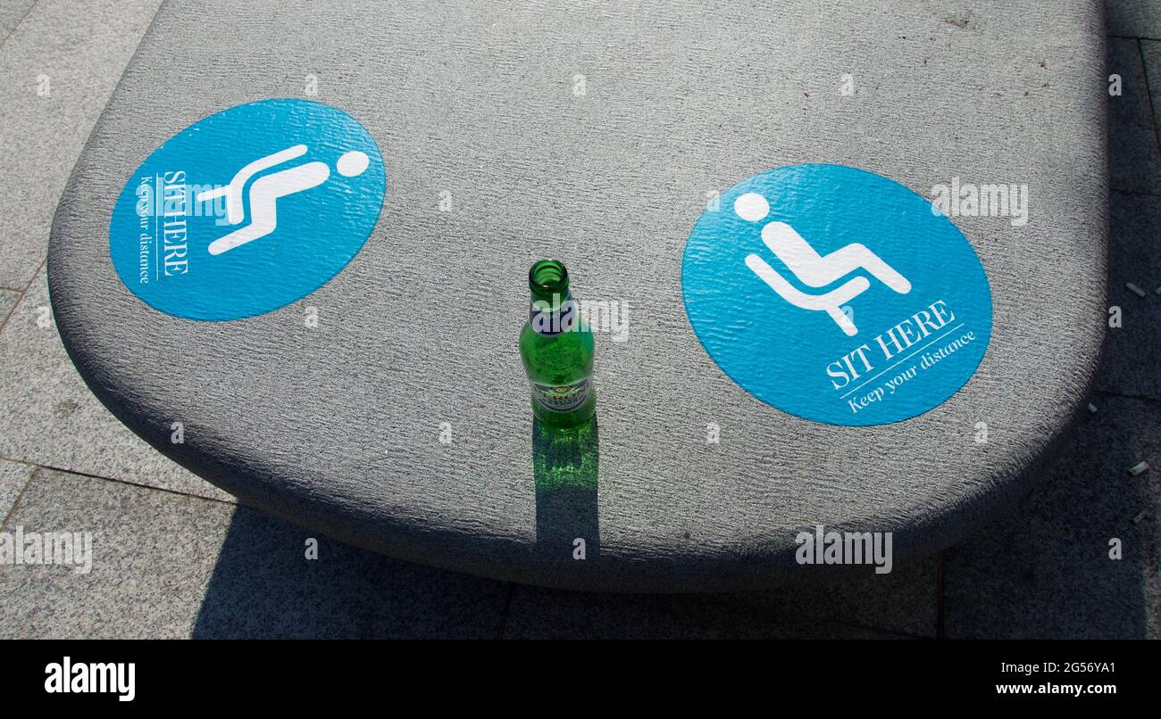 social distancing signs on public seats and a bottle of beer Stock ...