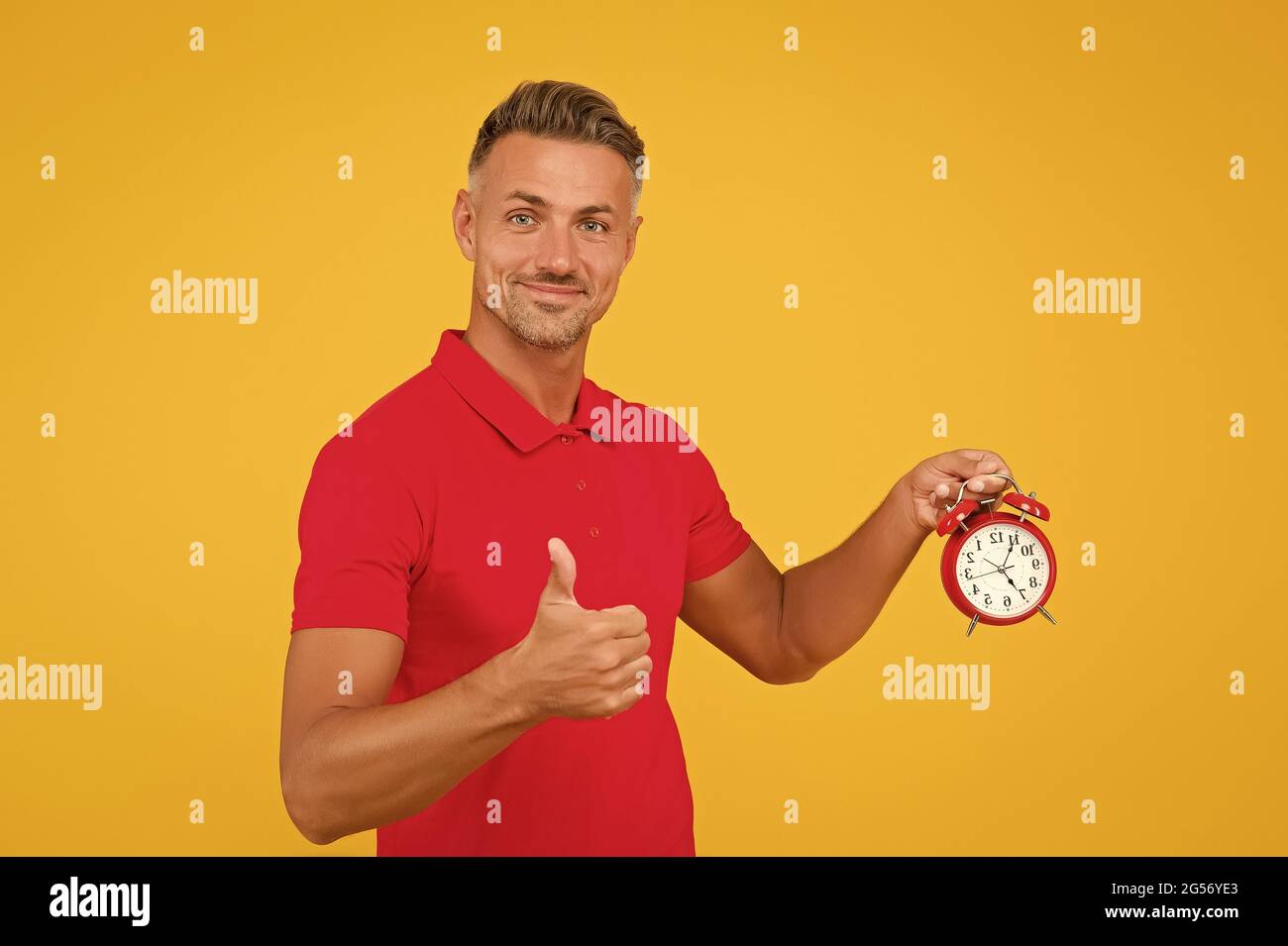 He is always punctual. Punctual man hold alarm clock showing thumbs up ...