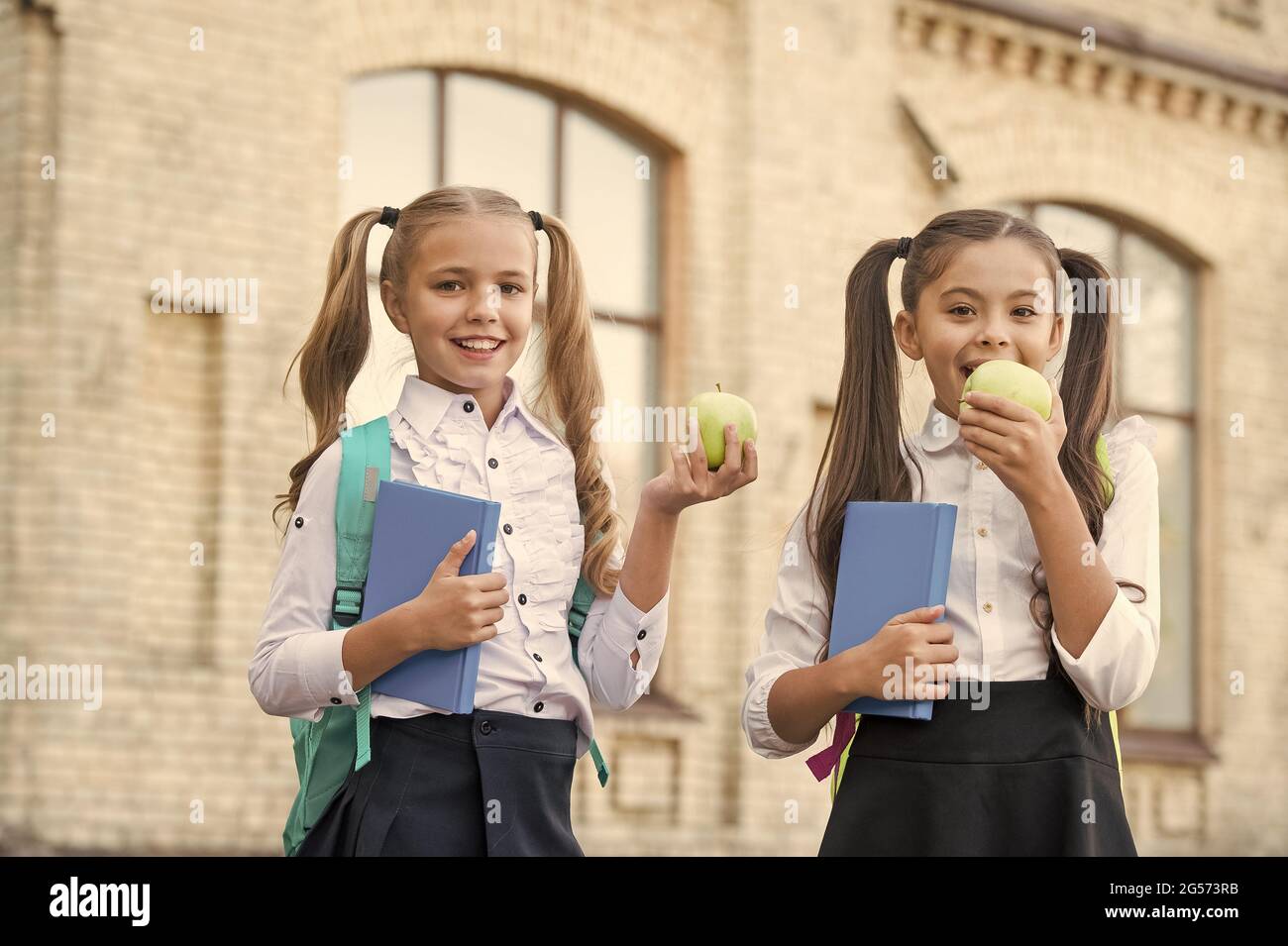 Students girls classmates with backpacks having school lunch, eating ...