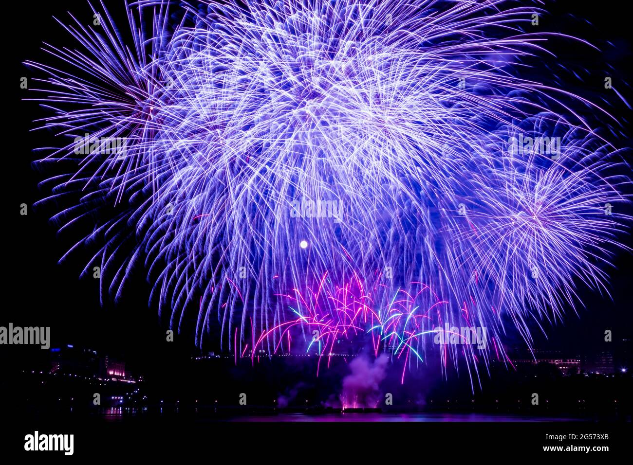 Purple fireworks fill the night sky over downtown skyline, with the ...