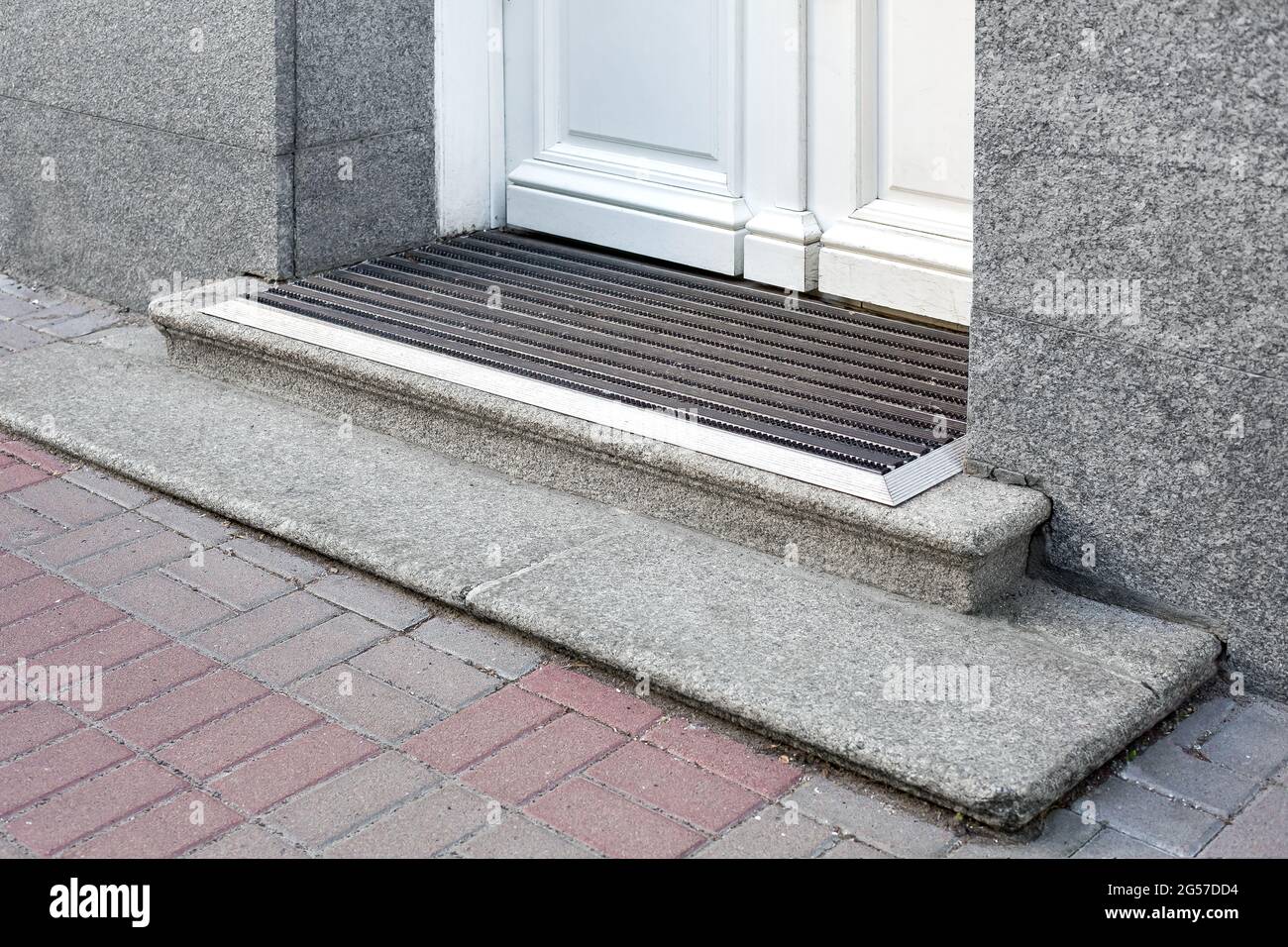 stone threshold with foot mat at the entrance door made of white wood ...