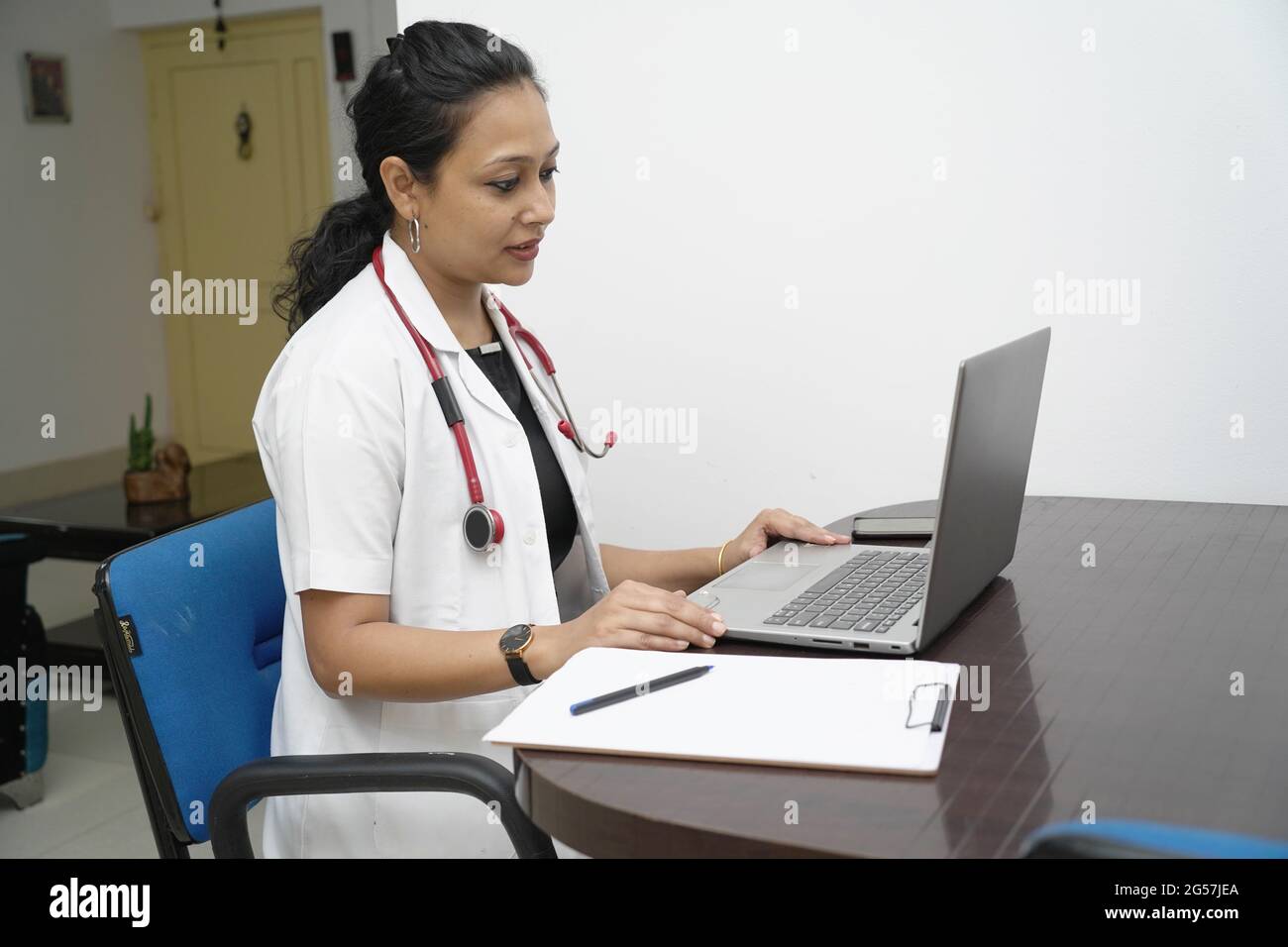A south Indian female doctor in 30s with laptop and prescription board ...
