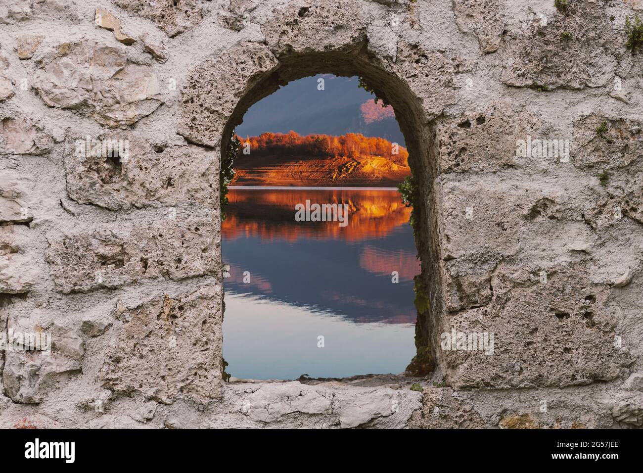 Scenic view of a tranquil lake seen through a stone arch window Stock ...