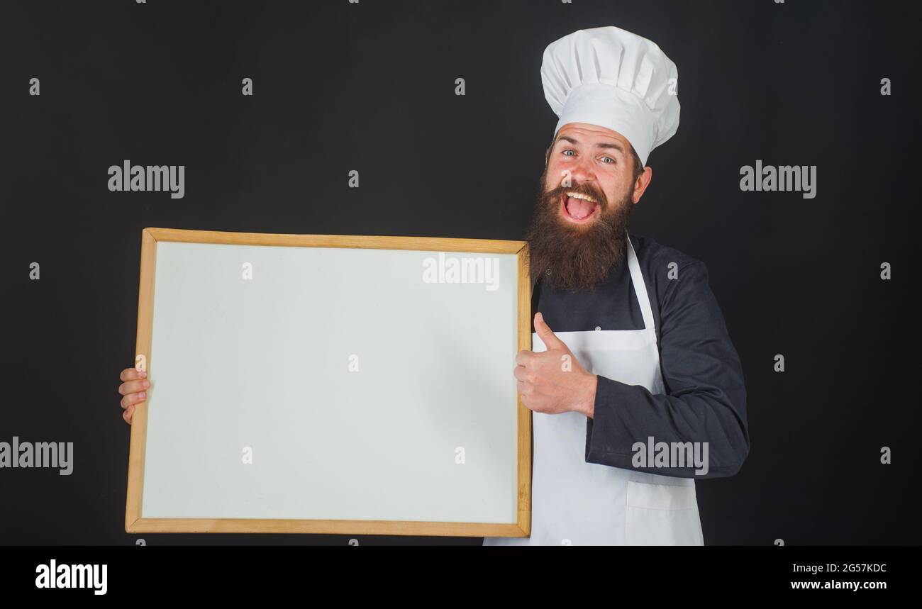 Chef with empty menu board. Smiling cook or baker shows thumb up ...