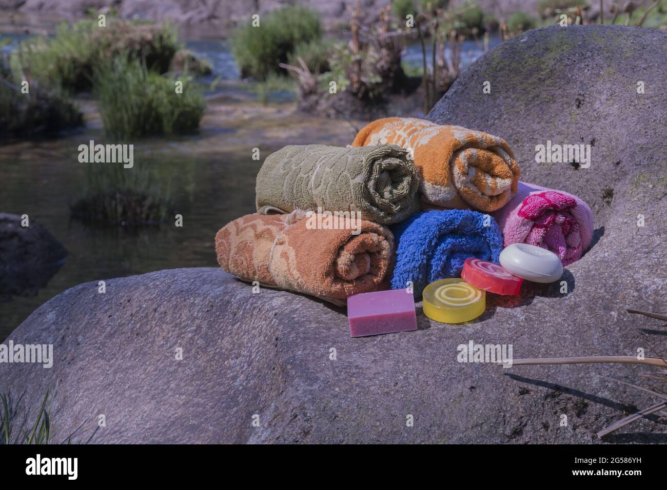 Pile of rolled colorful towels and decorative soaps near a river Stock ...