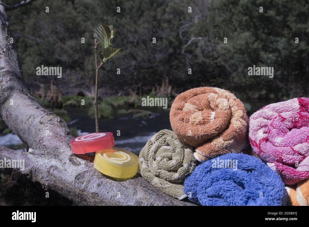 Pile of rolled colorful towels and decorative soaps near a river Stock ...
