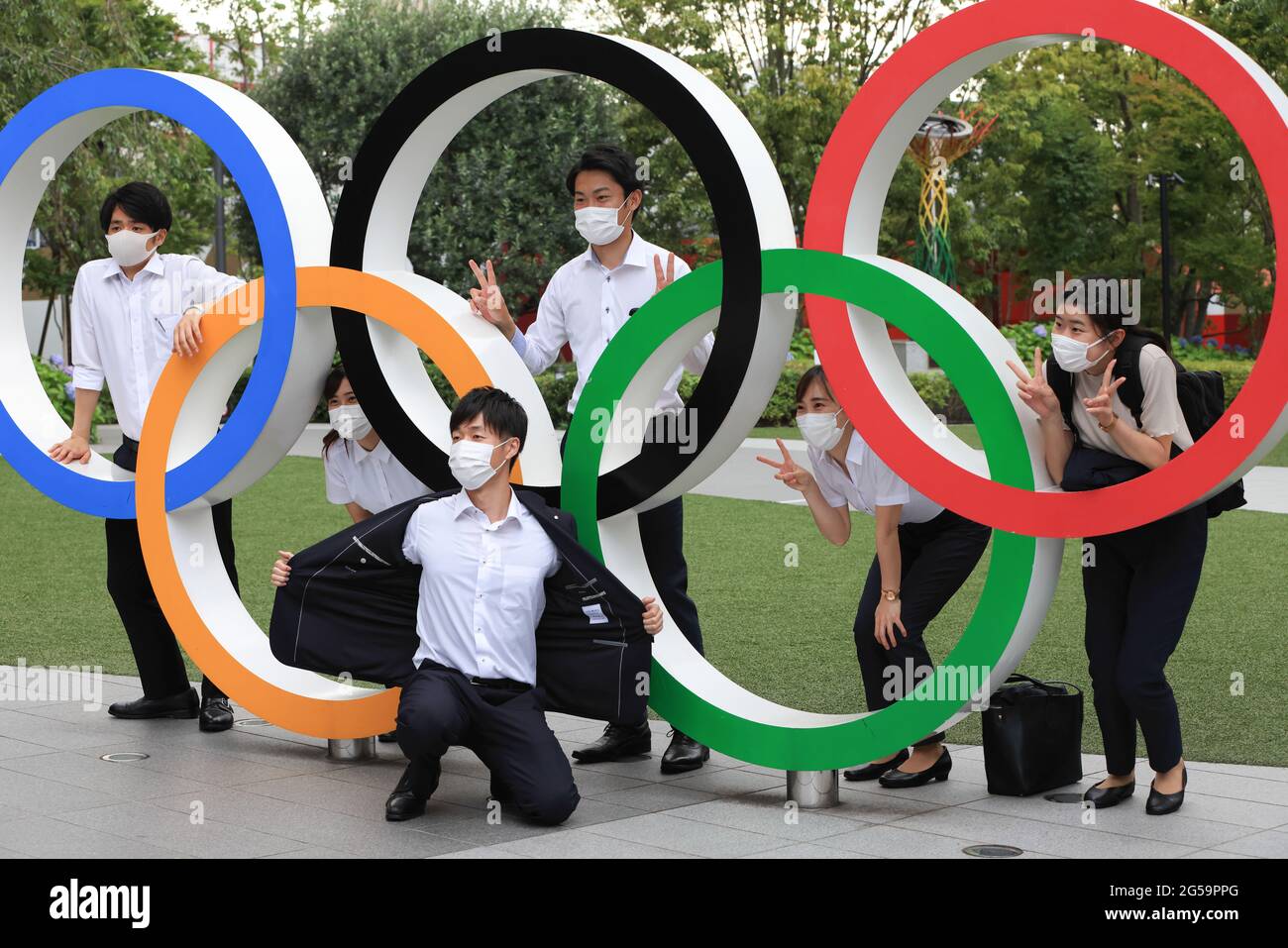 Fresh graduates with face masks take a photo in front of the Olympic ...