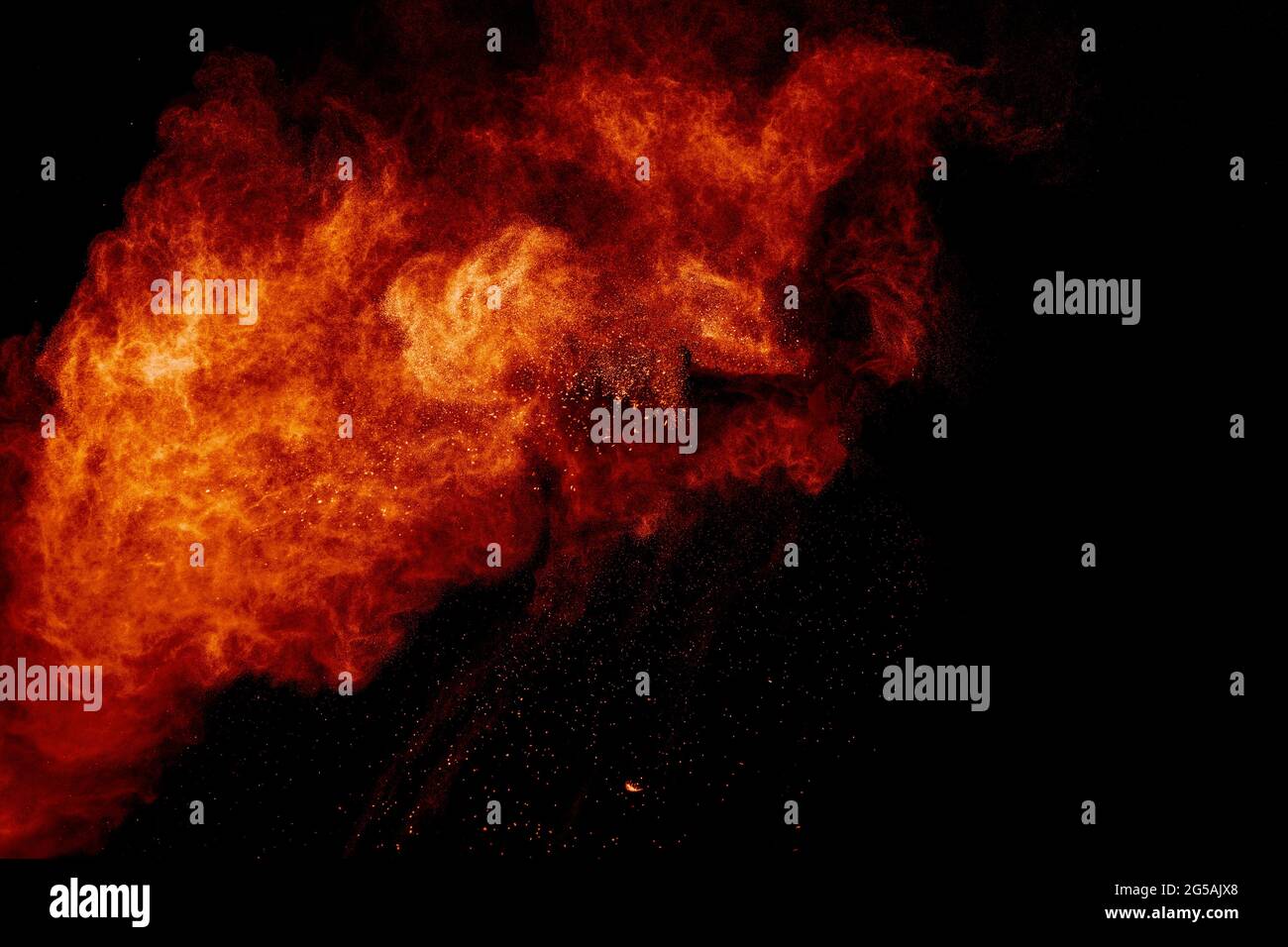 Orange powder splattered on black background.Abstract dust cloud ...
