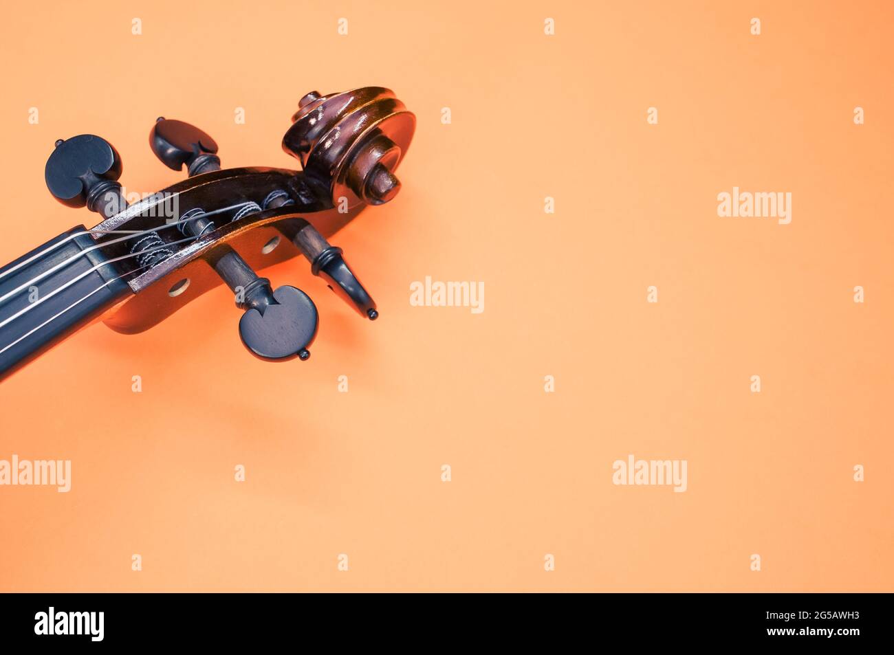 Pegbox of a violin on orange background with a copy space Stock Photo ...