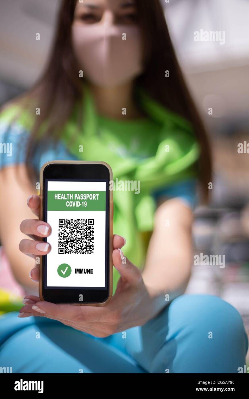 Portrait travel woman in face mask with digital app health passport ...