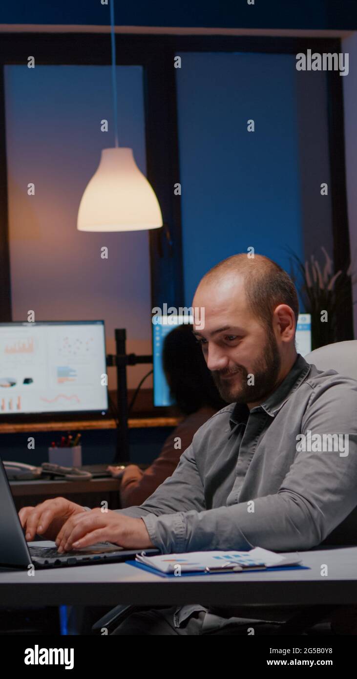 Exhausted businessman checking marketing statistics on laptop computer ...