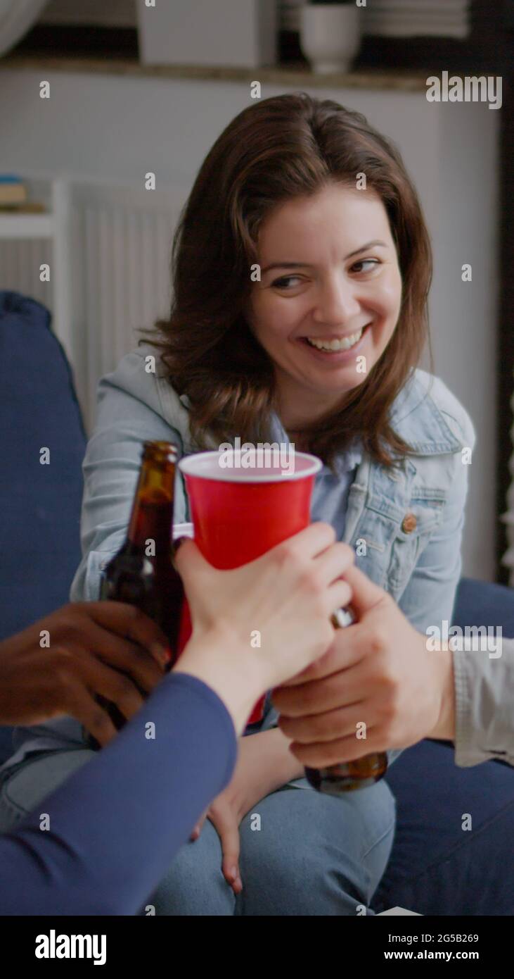 Multi cultural friends cheering beer bottles during wekeend party ...