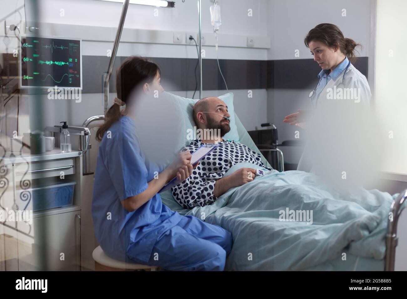 Patient talking with doctors while resting in bed during disease ...