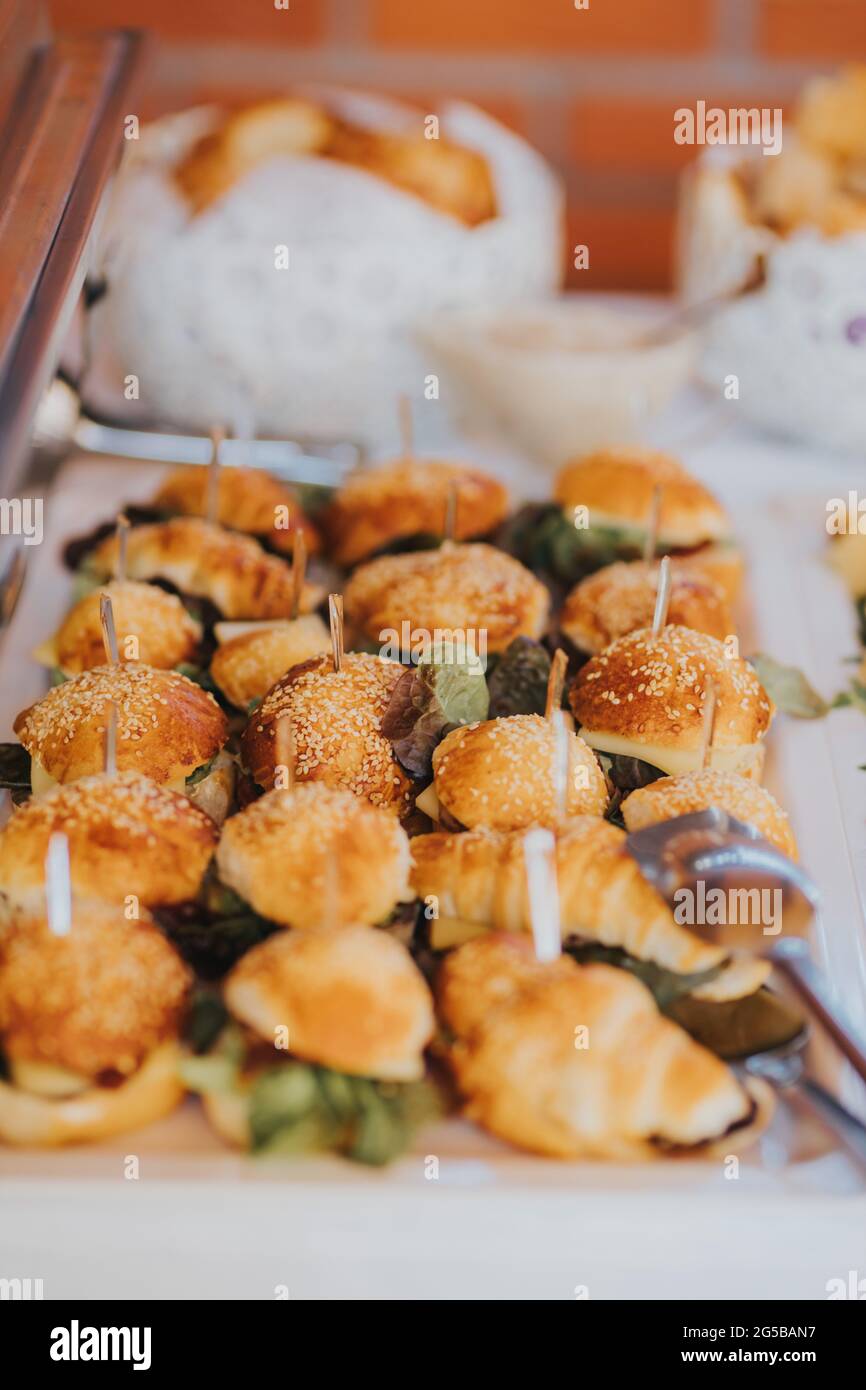 Vertical shot of a set of burgers and sandwiches on a buffet table ...