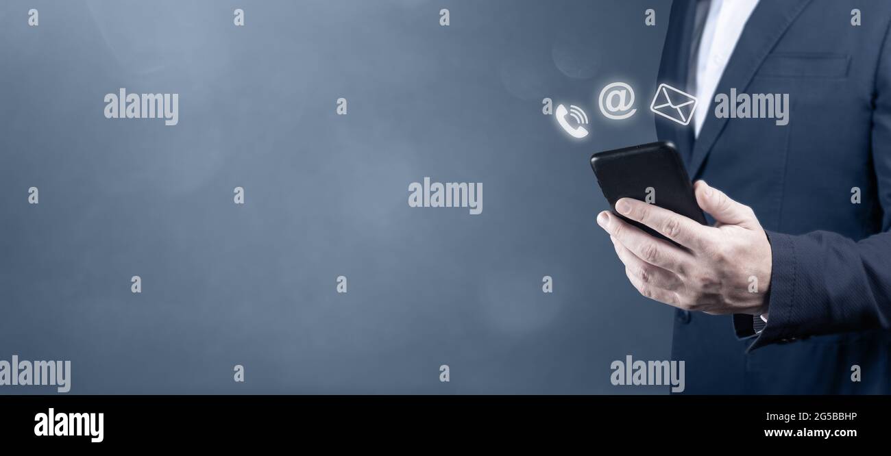 CONTACT US. businessman holding cell phone with with mail, phone, email ...