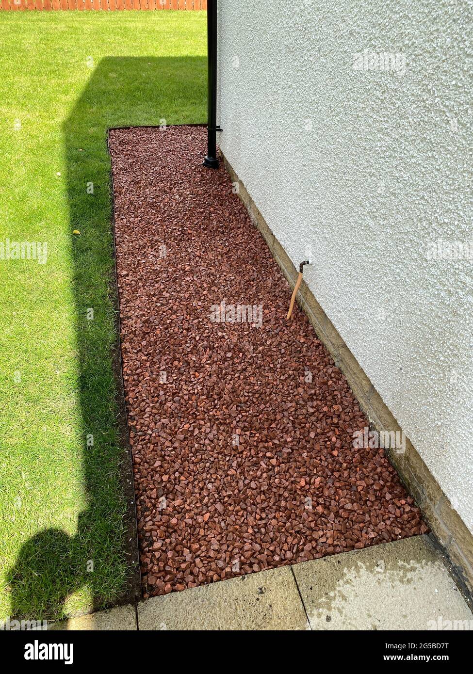 Red stone garden path at back of house Stock Photo - Alamy