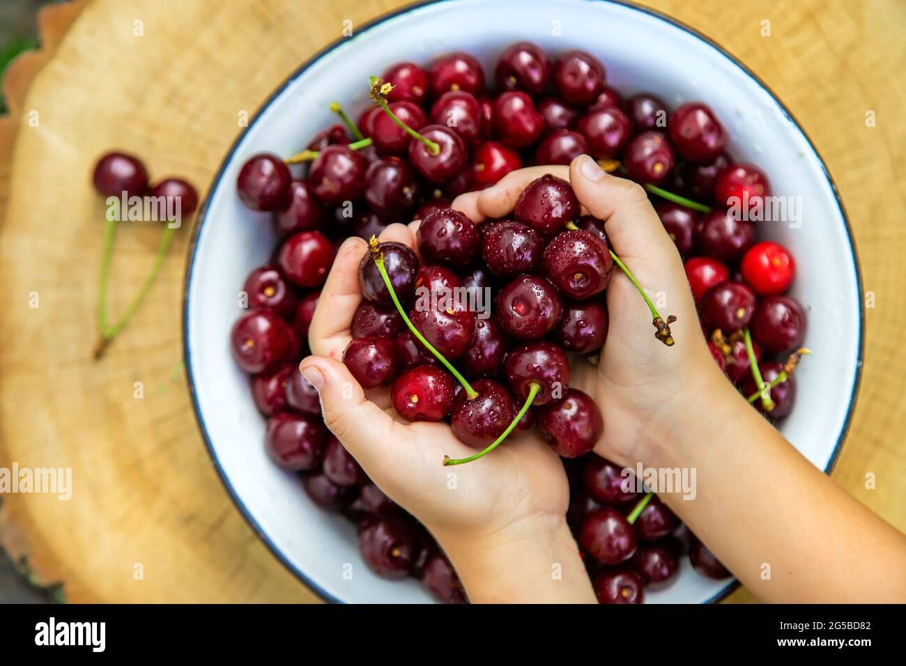 The child eats cherries in the garden. Selective focus. Food Stock ...