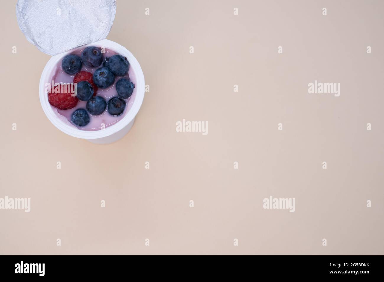 Top view of a berry yogurt in a plastic cup on a beige background Stock ...