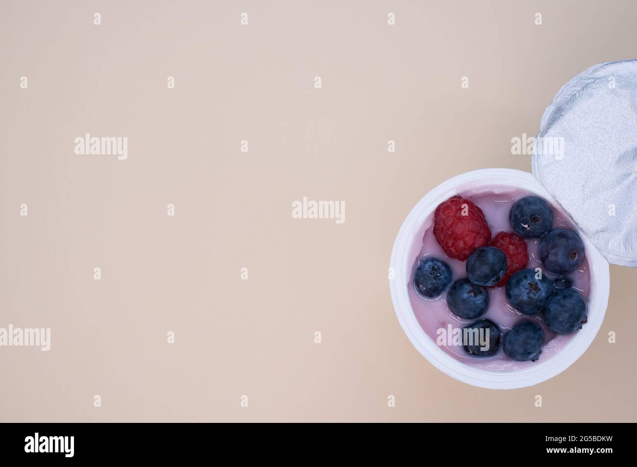 Top view of a berry yogurt in a plastic cup on a beige background Stock ...