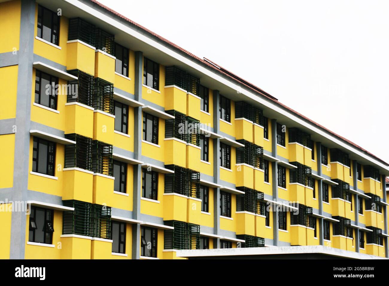 Yellow-black building facade with balconies Stock Photo - Alamy