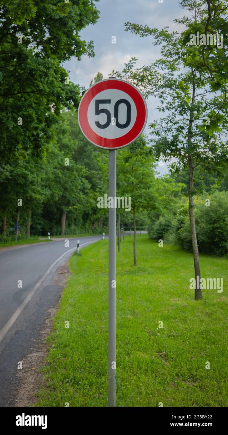 Speed limit "50" road sign on background of the highway and trees Stock ...